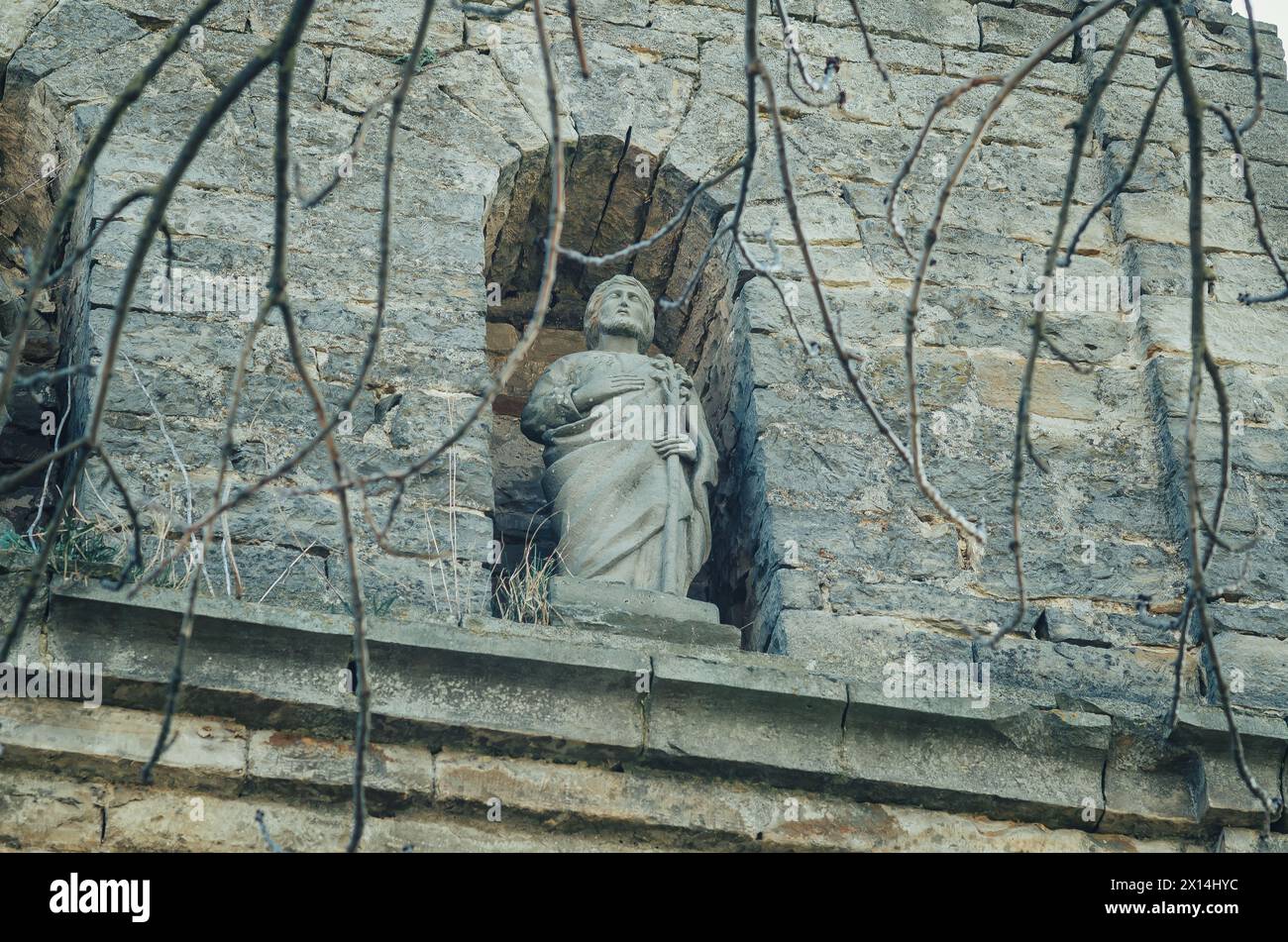 Statue of ancient man in arch of stone church wall. Religious ...