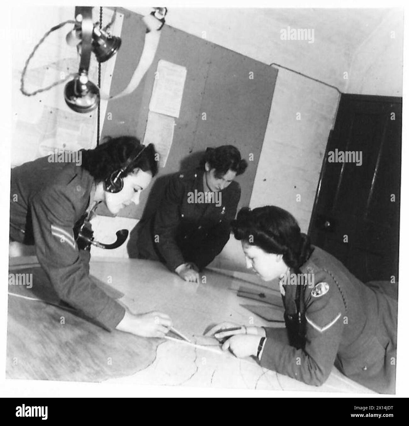 ATS personnel plot the course of enemy ships using a large-scale map of ...
