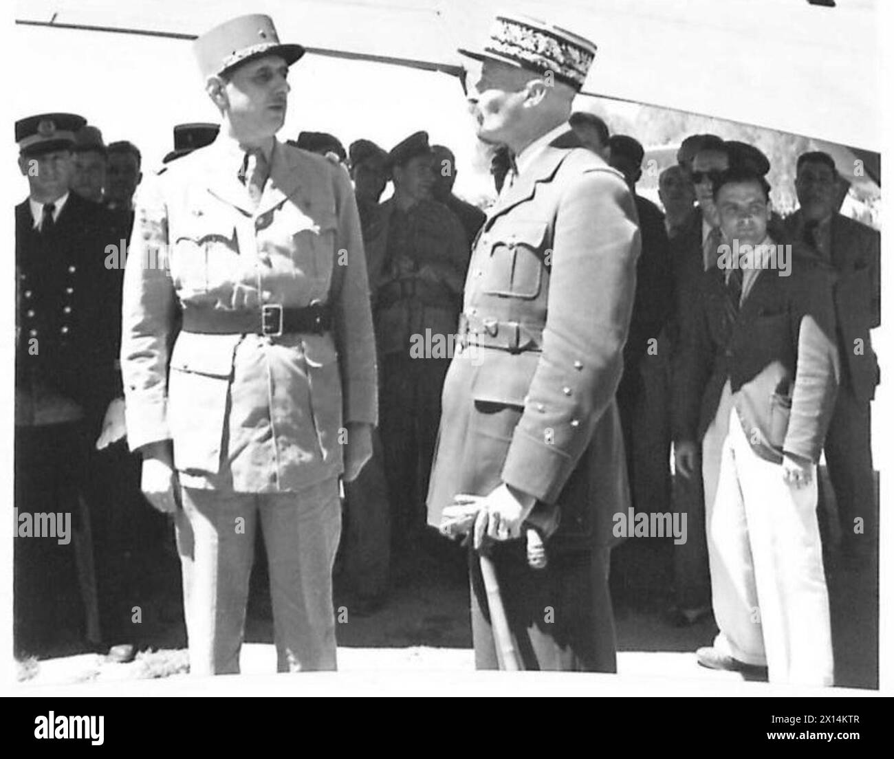 Generals Charles de Gaulle and another general converse beside a plane ...