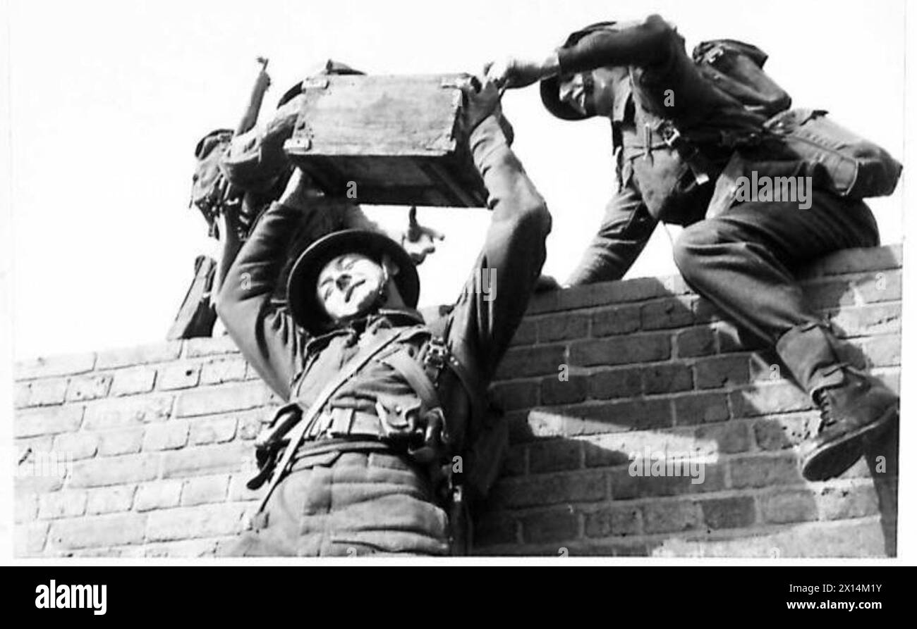 TOUGHENING UP - Men passing boxes of ammunition over a ten foot wall ...
