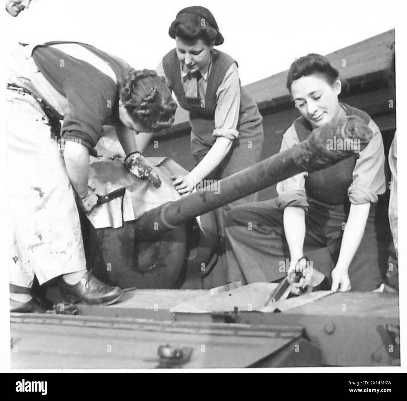 ATS convoy drivers and storeswomen are shown sealing a tank gun using ...