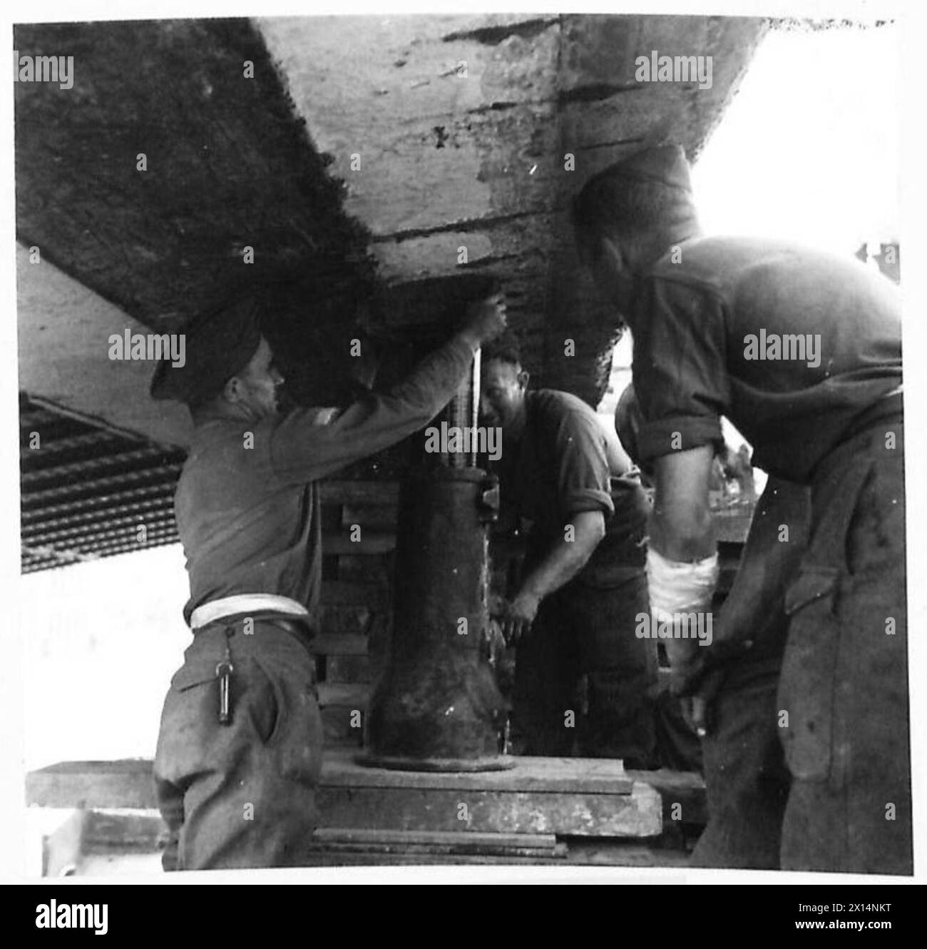 A wedge is placed under a 100-ton jack during bridge rebuilding in Caen ...