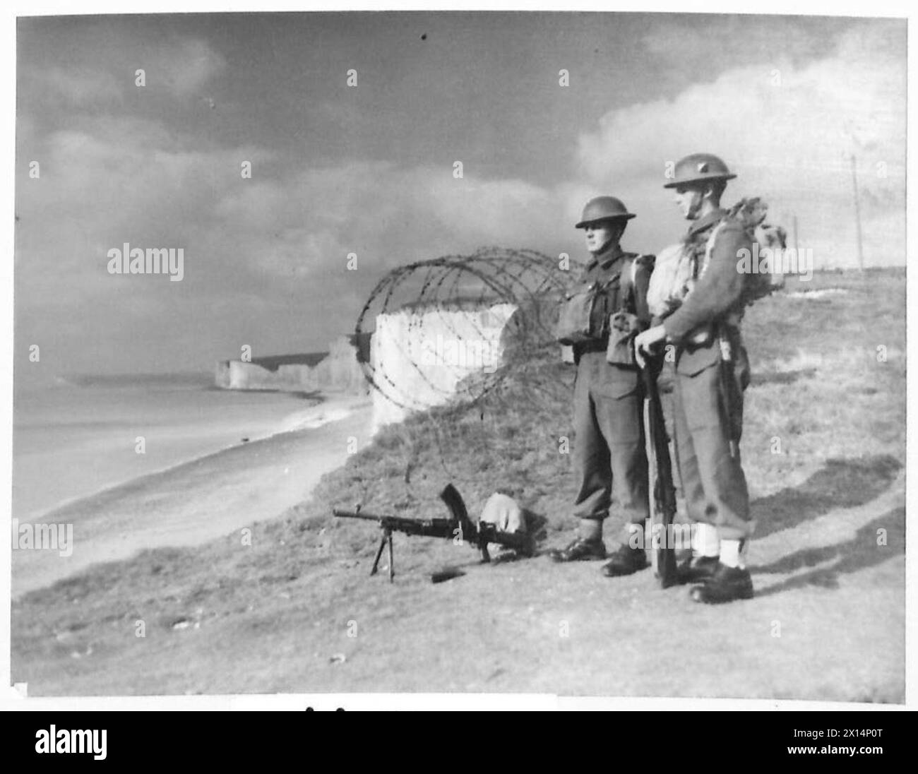 Sentries guard coastal cliffs with barbed wire entanglements and a Bren ...