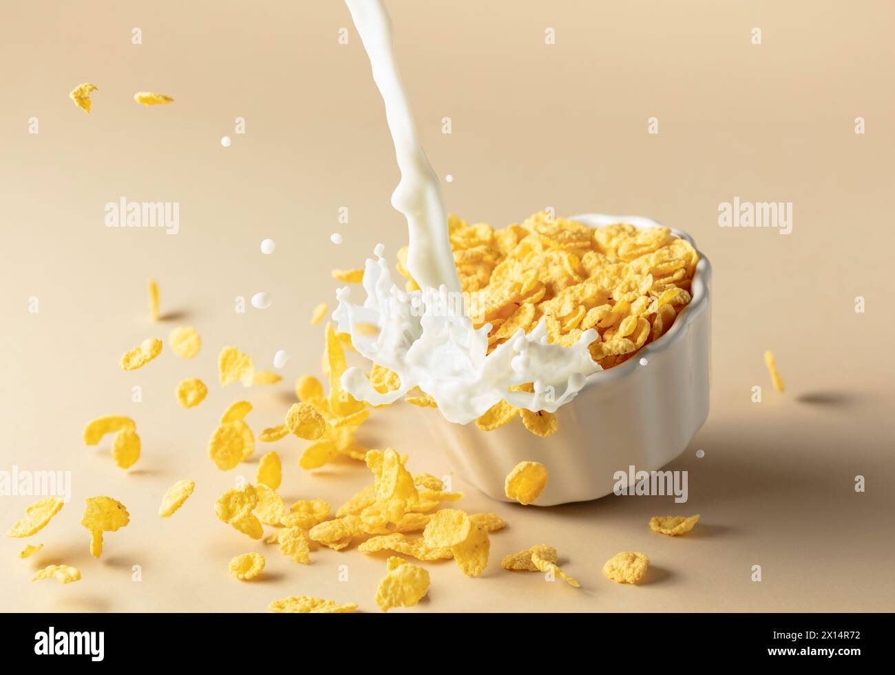 Dry honey cornflakes with milk splashes in a ceramic plate. Flakes with ...