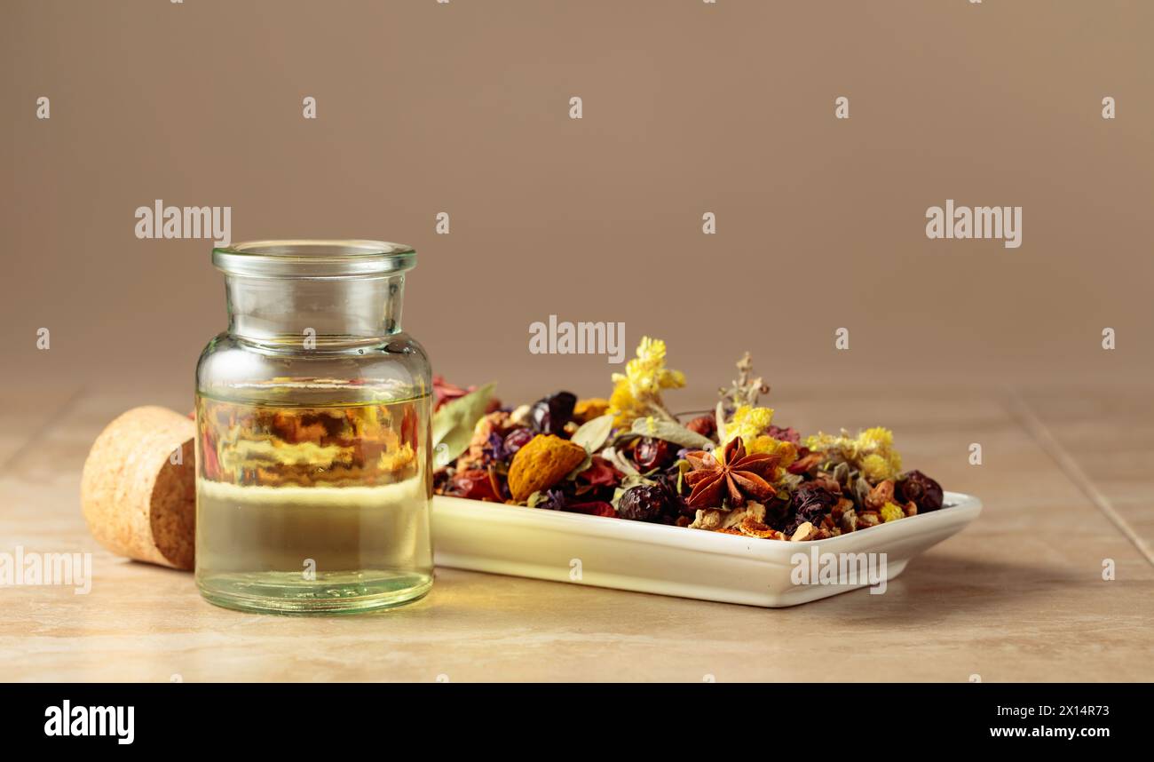 Essential oil or herbal tincture in a small glass bottle. Mix of dried ...