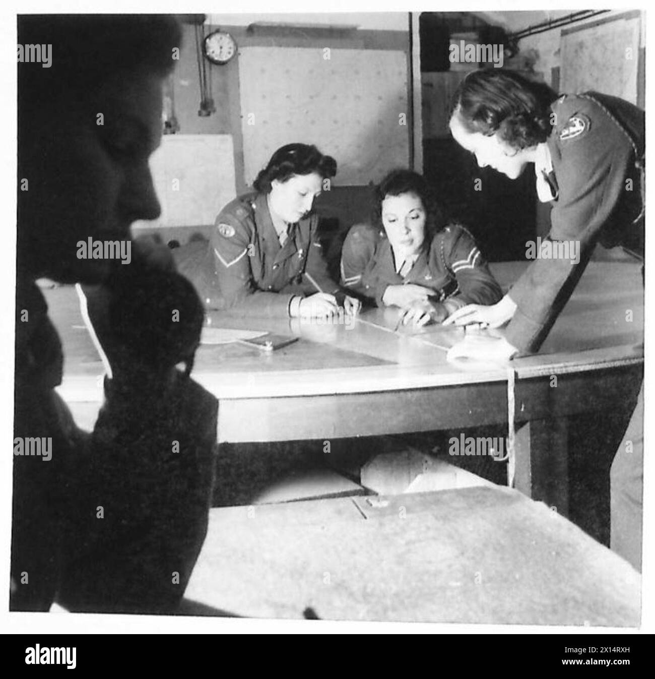 ATS personnel work in the plotting room, using a large-scale map of the ...