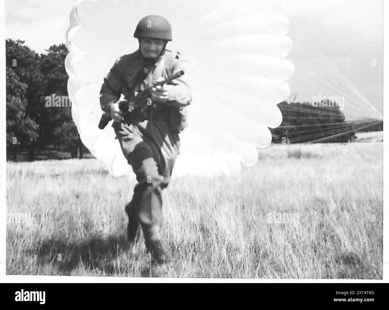 A paratrooper gathers arms from a container and moves from the rallying ...