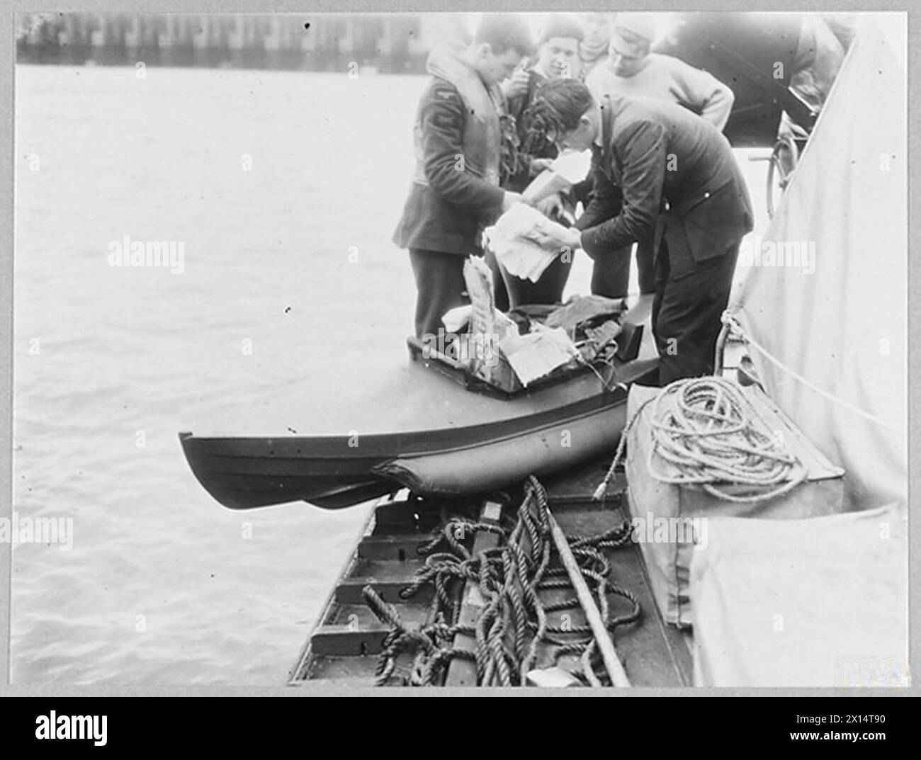 The crew of HSL.180 examines a small rubber canoe used to rescue a ...