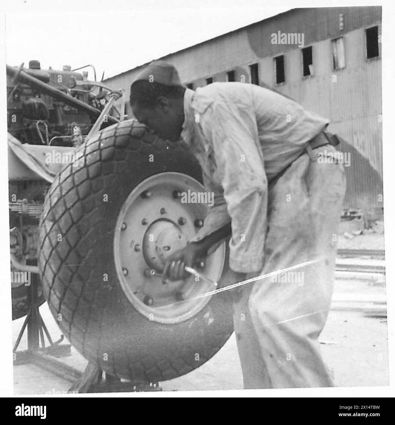 A Basuto worker attaches a wheel to the chassis of a Canadian truck ...