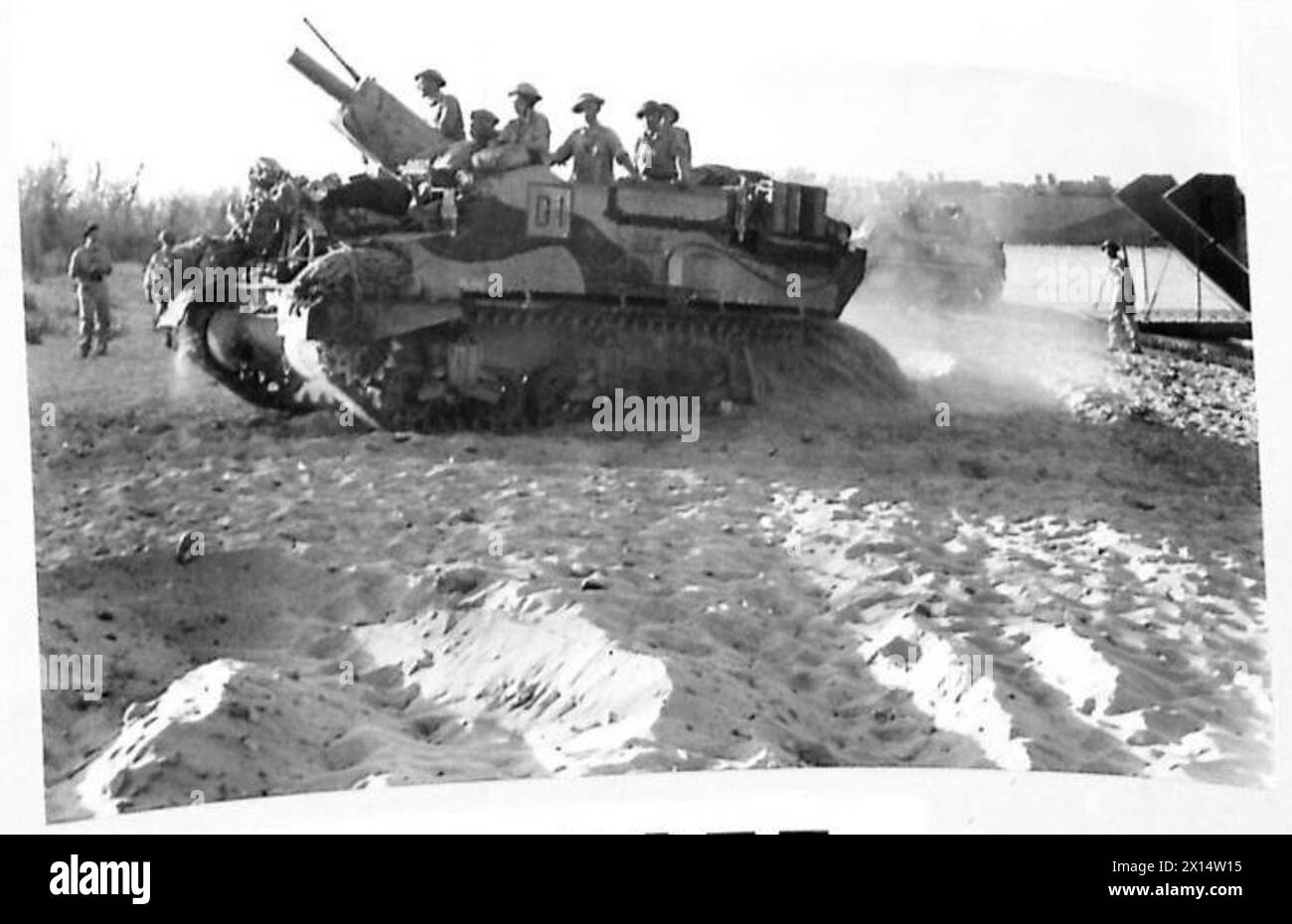 The armoured vehicle 'Priest' advances up the beach during the invasion ...