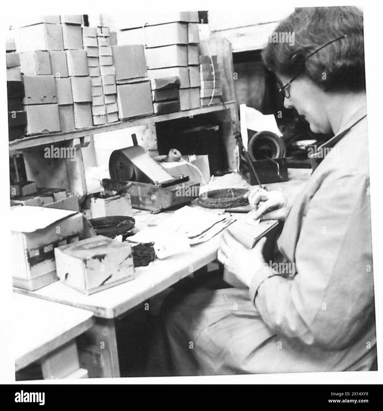 A girl labels boxes as part of the packing system at Chilwell Ordnance ...