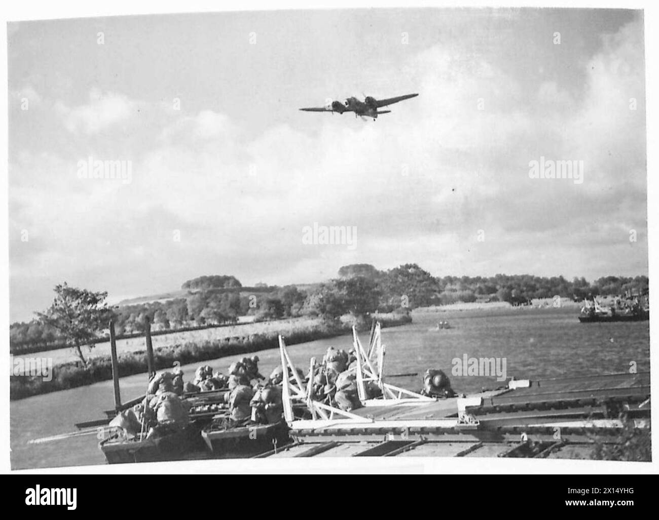 THE ARMY'S BRIDGE BUILDERS - A bomber flies over as the bridge is being ...