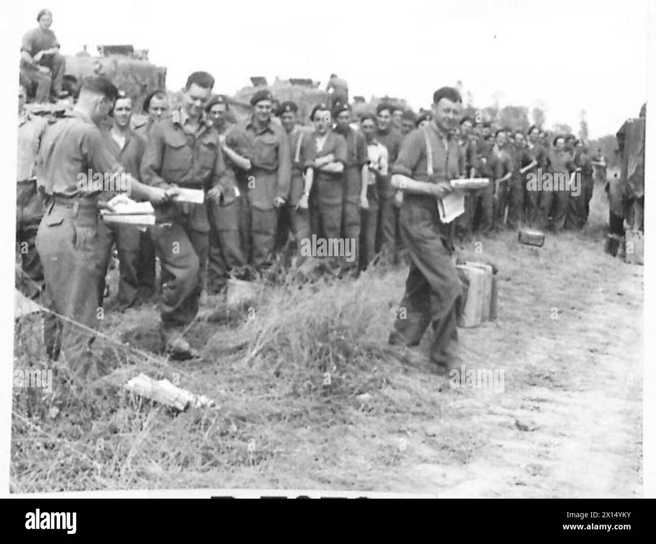 SCENES IN CAEN - Tank crews of 31 Tank Brigade line up for newspapers ...