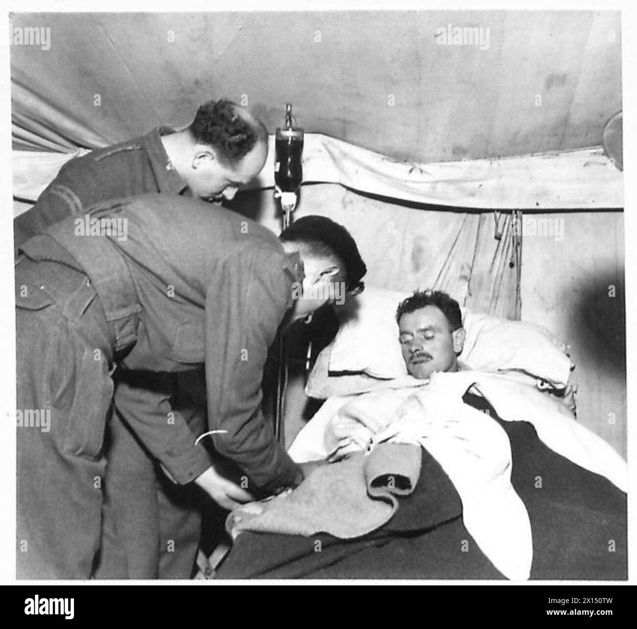 Capt. A.L. Tulk of the RAMC administers a blood transfusion to Private ...
