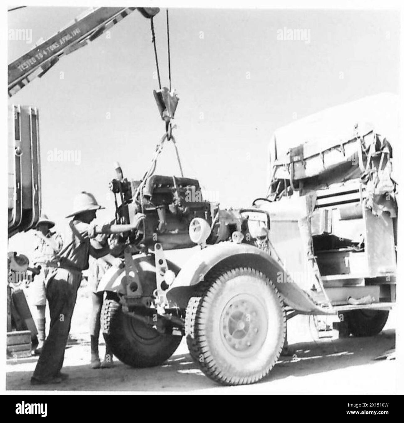 A soldier lifts an engine from a lorry for overhaul and maintenance ...