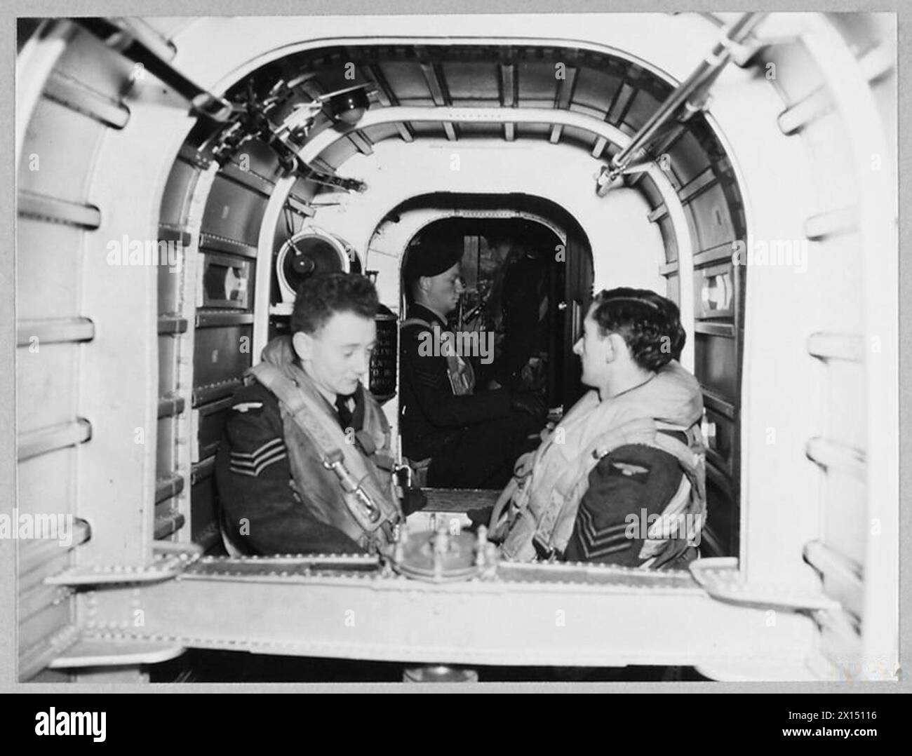 Three RAF air gunner trainees take turns at firing practice while a ...