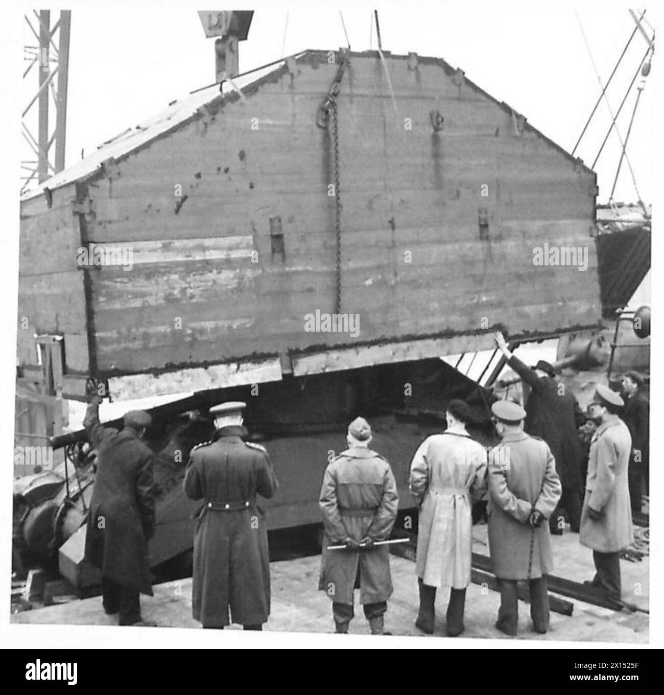 Officers observe the removal of a crate containing supplies or ...