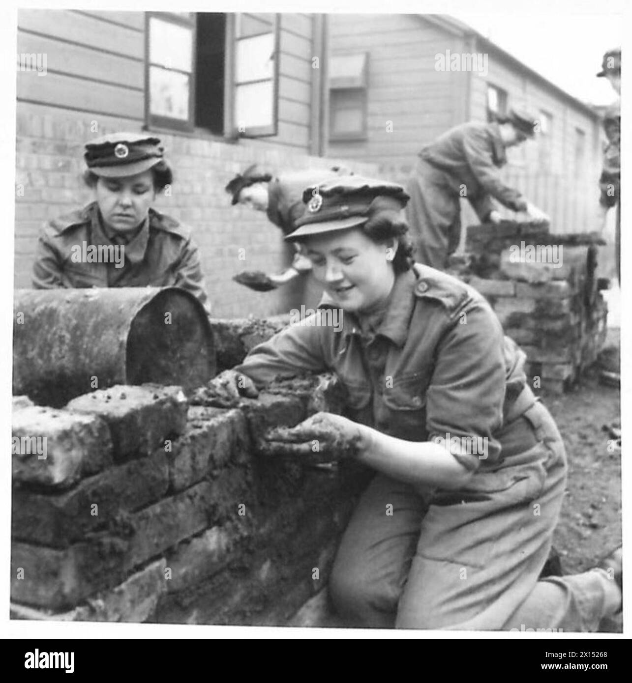 ATS personnel constructing a field kitchen using bricks and clay under ...