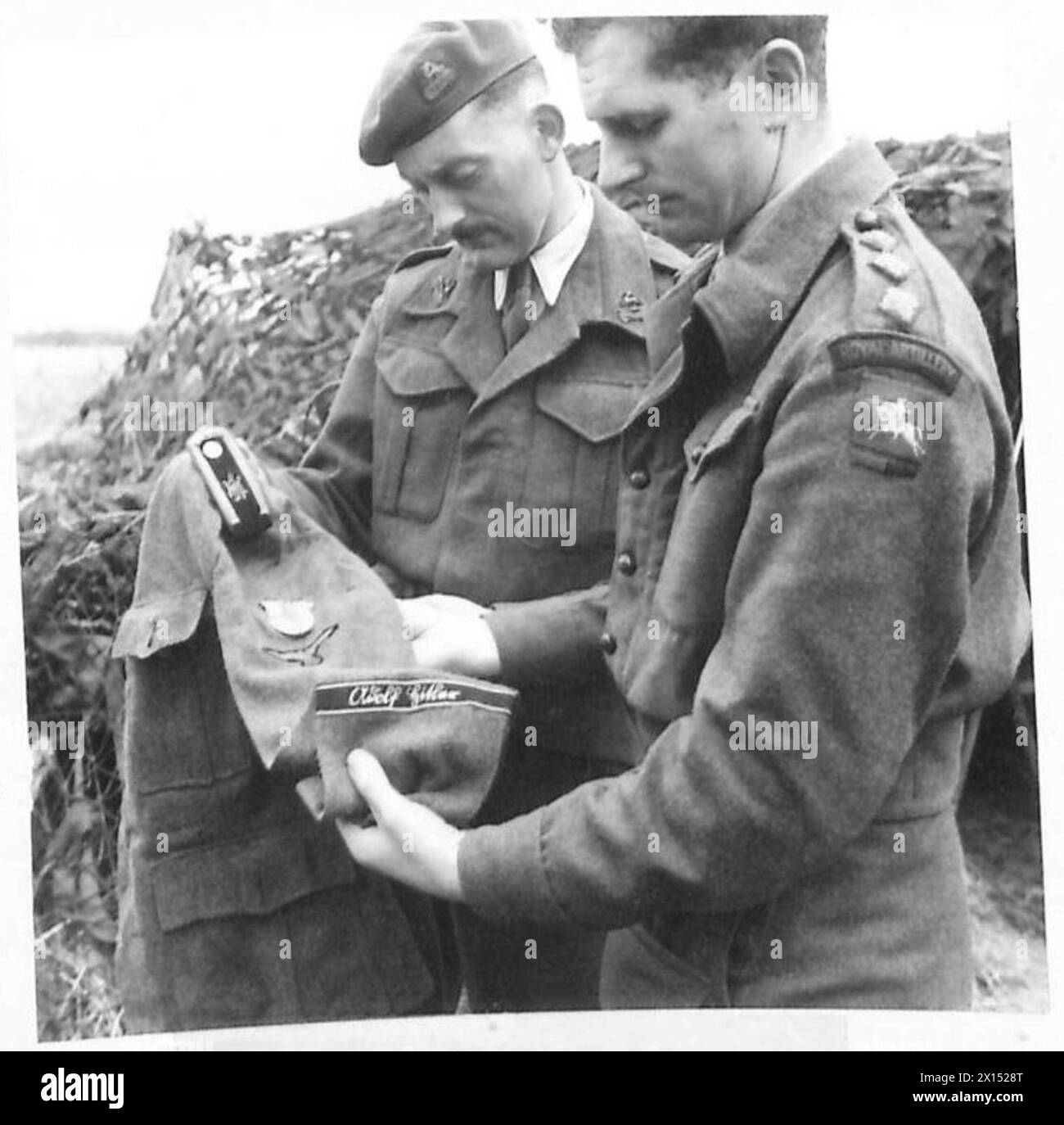 Shows British Army officers examining the tunic of a corporal in the ...