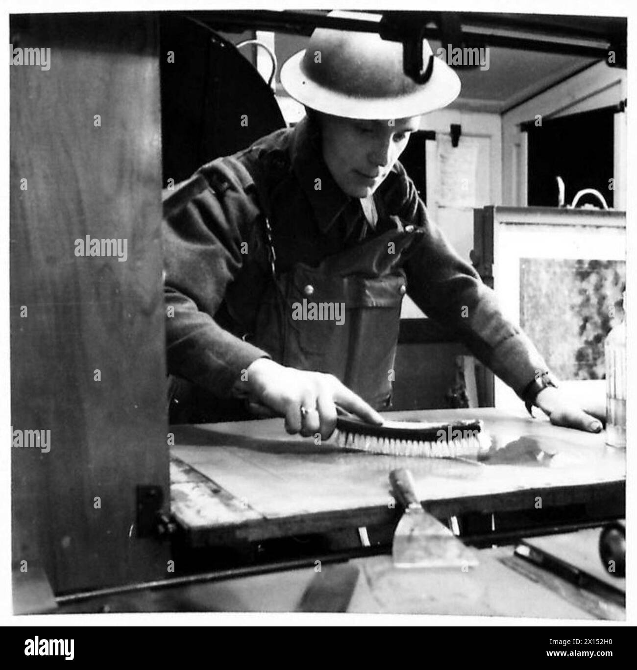 British Army personnel in a mobile map-making unit load paper into a printing machine as part of ...
