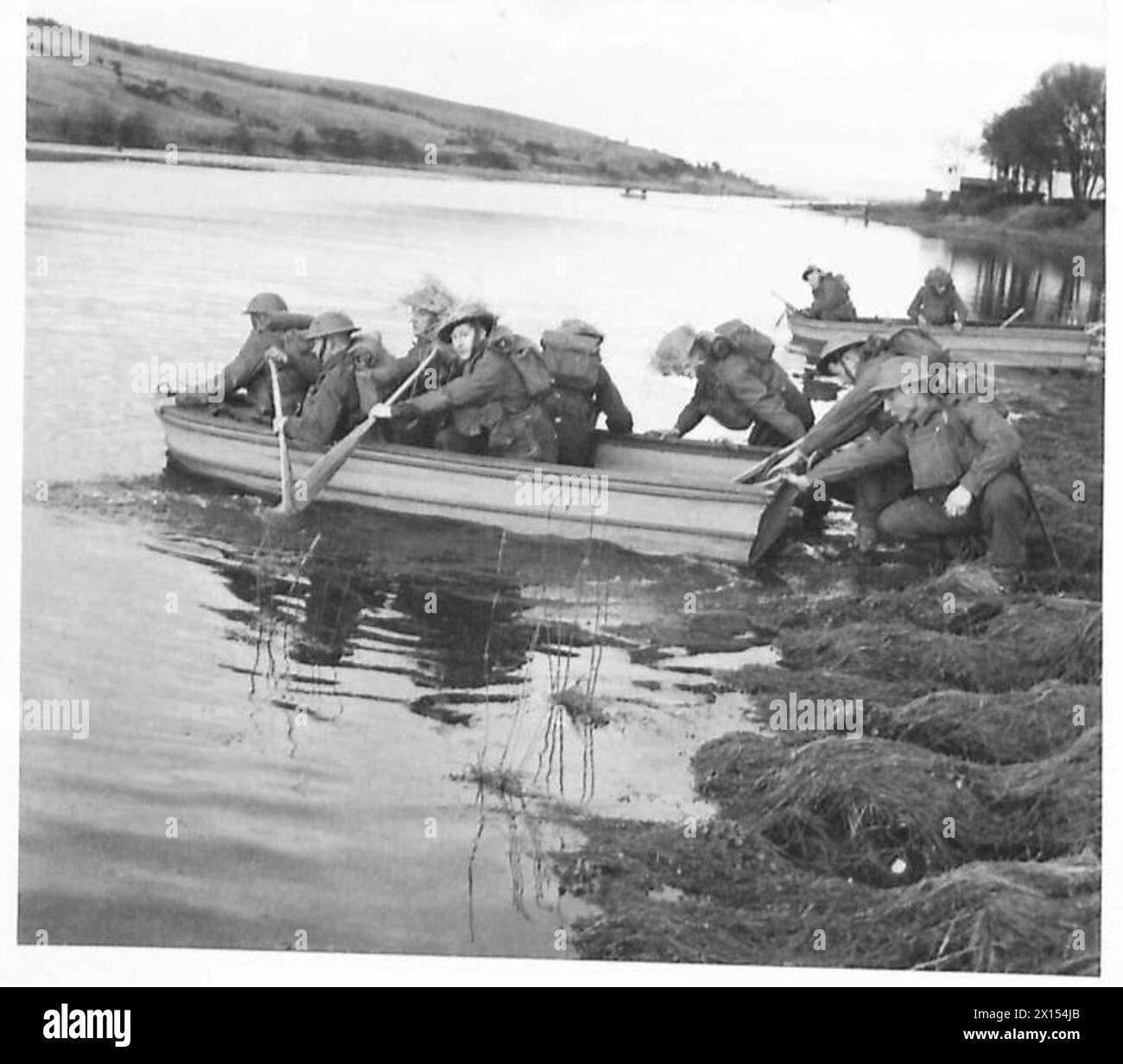 Troops cross a river in collapsible boats during a British Army ...