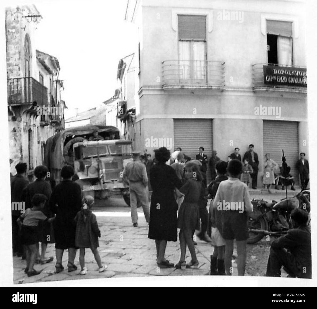 169 Brigade, 56 Division advances through the village of Penta after ...