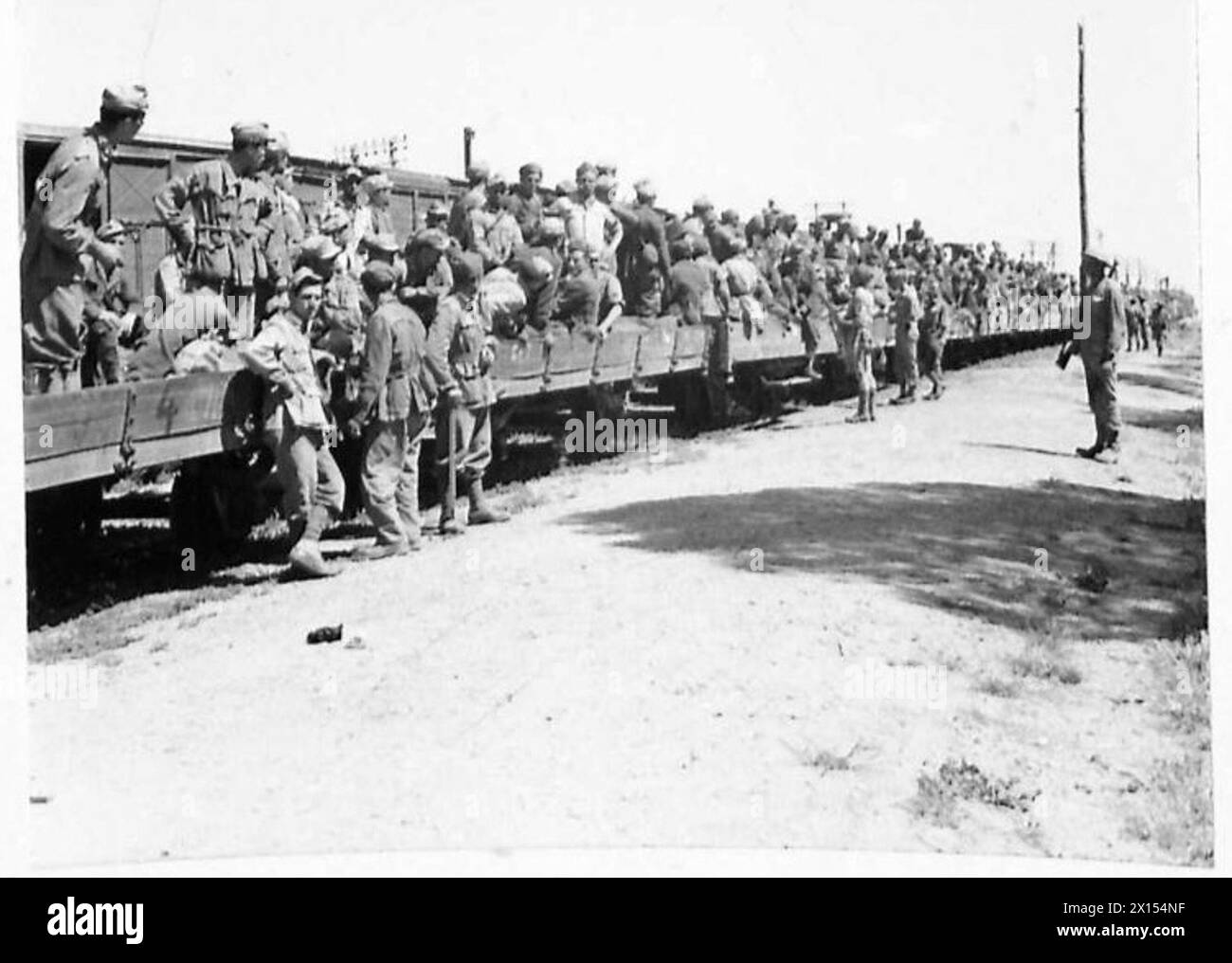 Prisoners climb into railway wagons for transport to prison compounds ...