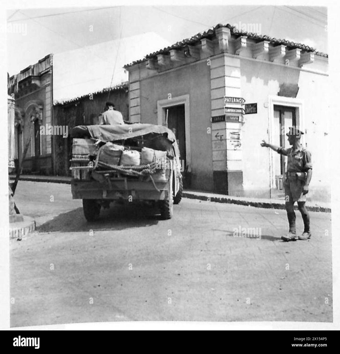 A British Army vehicle passes through Belpasso, Sicily, on its way to ...