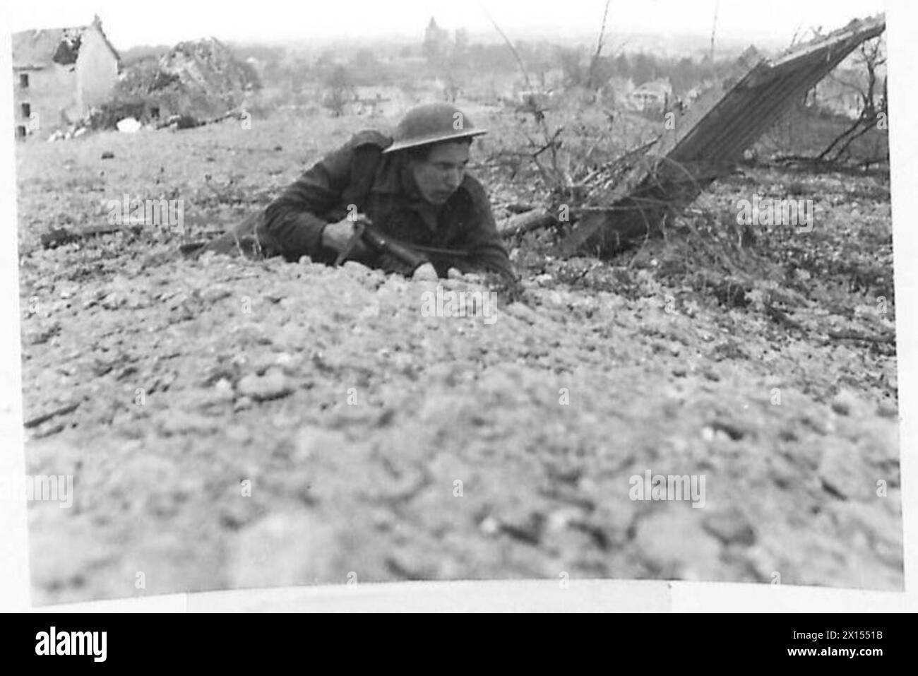 A British soldier is seen crawling through rubble on the outskirts of ...
