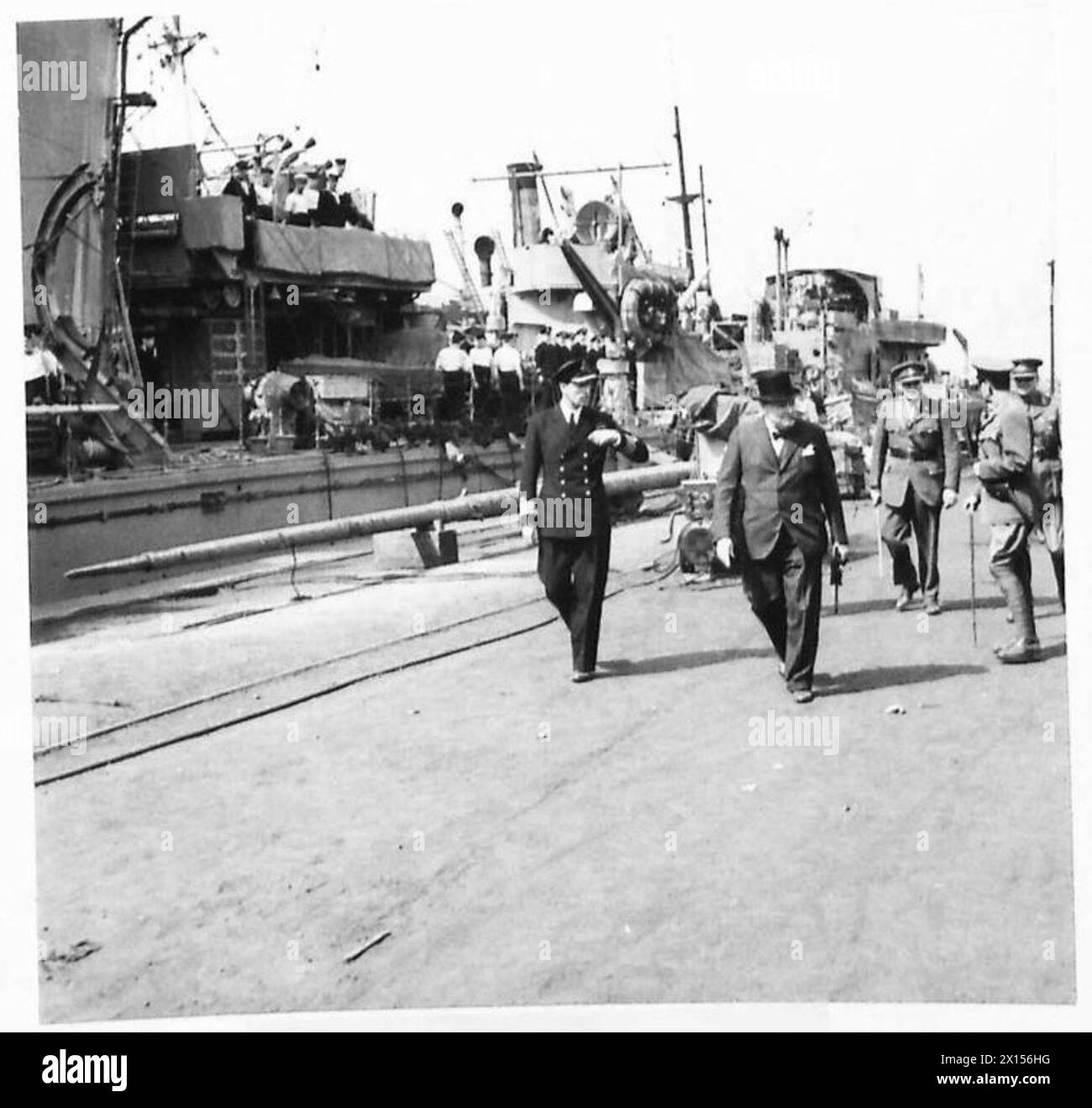 Prime Minister Winston Churchill tours a naval establishment, passing a ...