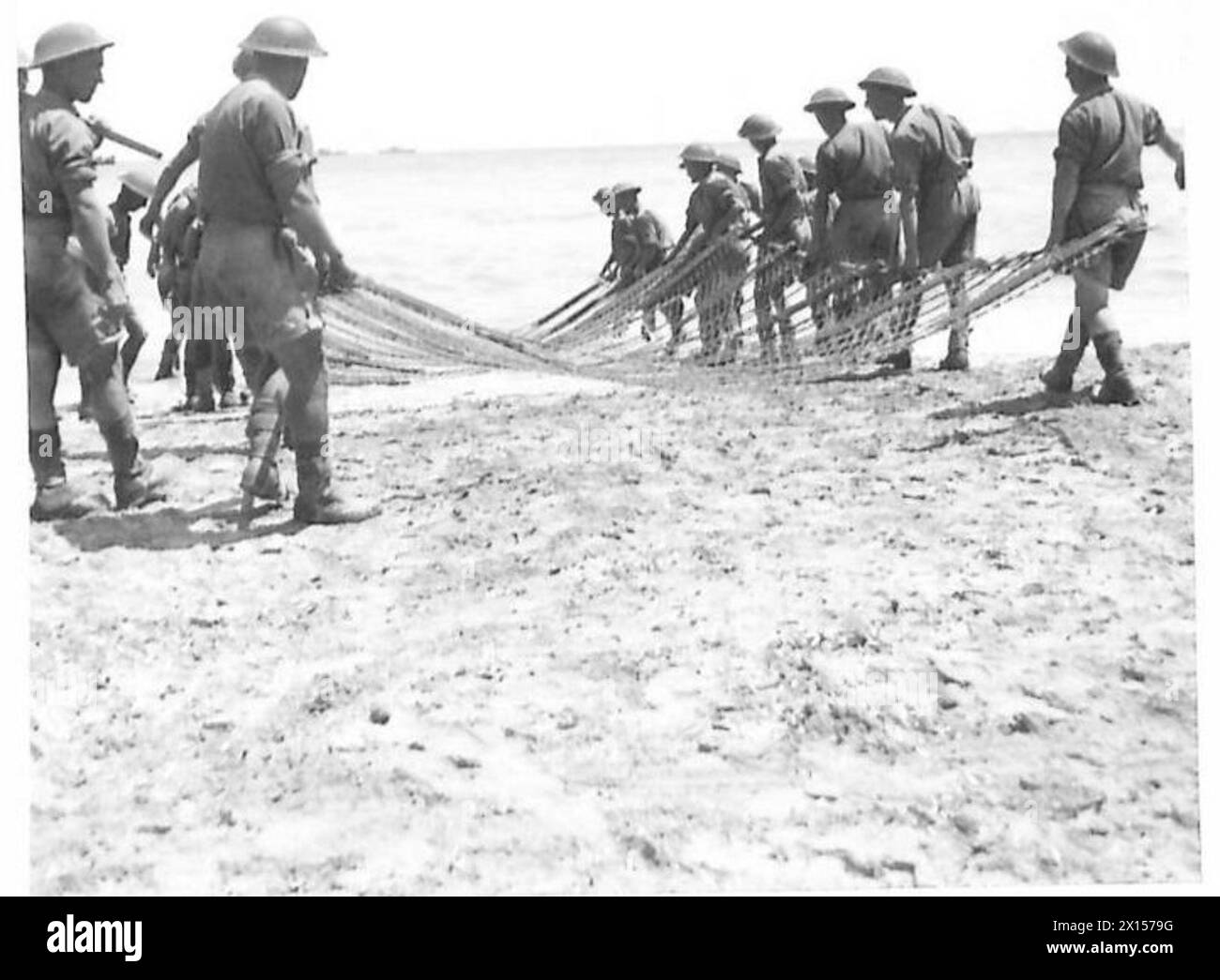 British Army pioneers lay a wire road on the beaches at Cape Passero ...