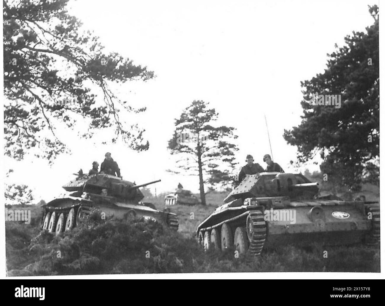 British Army Covenanter tanks maneuver out of woodland cover as part of ...