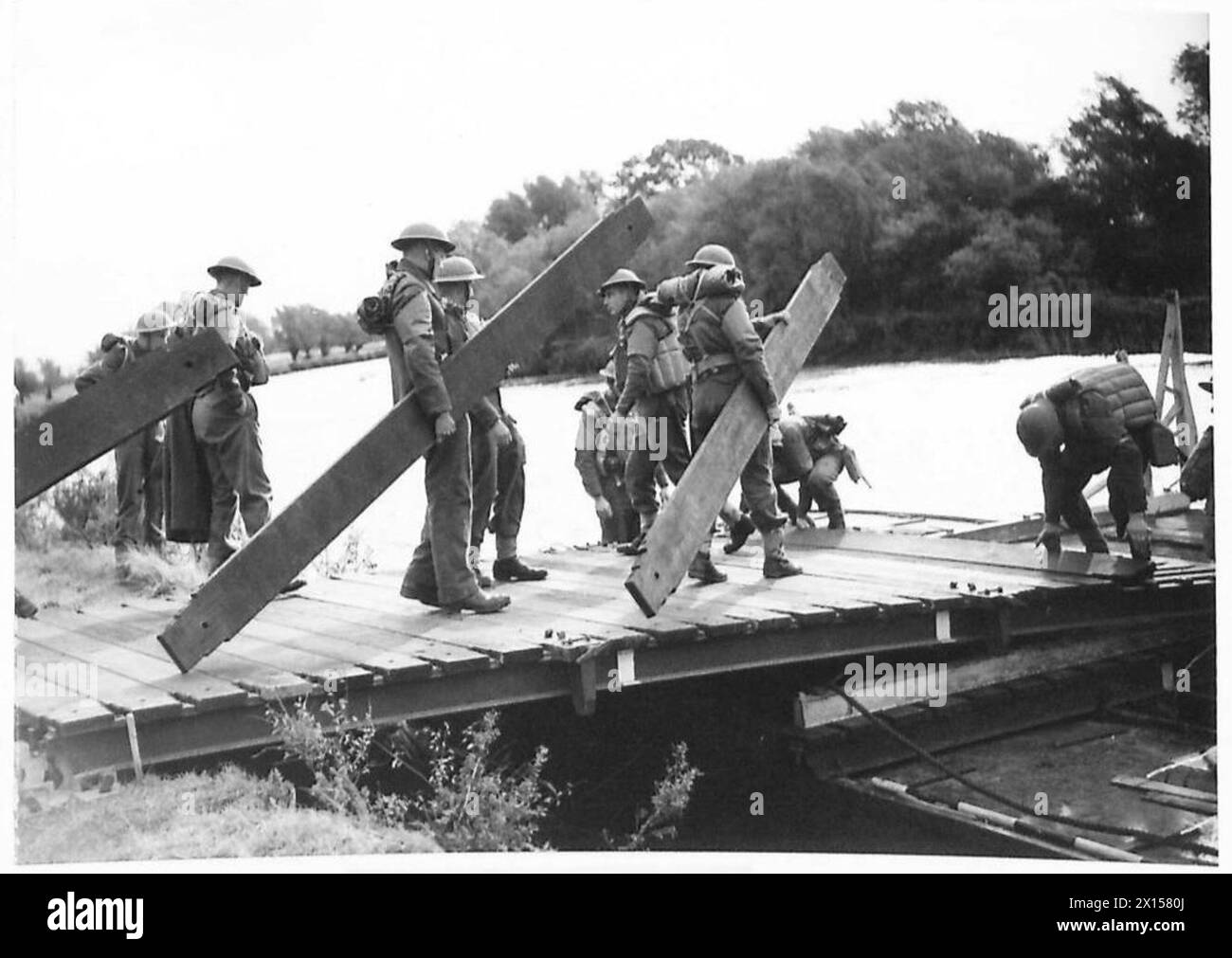 THE ARMY'S BRIDGE BUILDERS - Planks being taken aboard the pontoon to ...