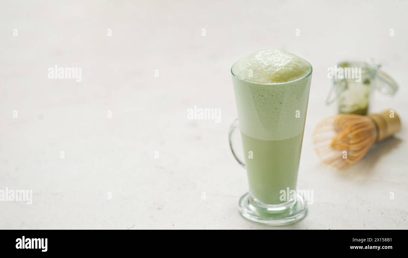 Matcha green tea latte in glass. Matcha latte on light background. Copy ...