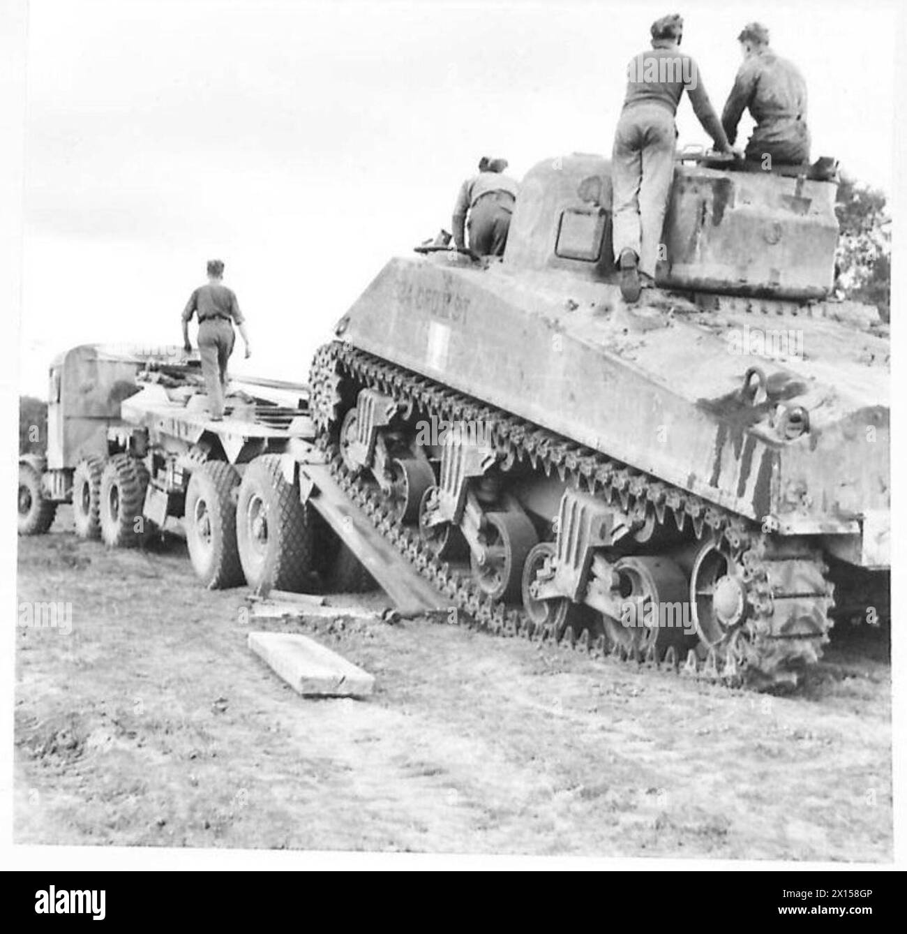 A Sherman tank of the British Army is loaded onto a Scammel vehicle for ...