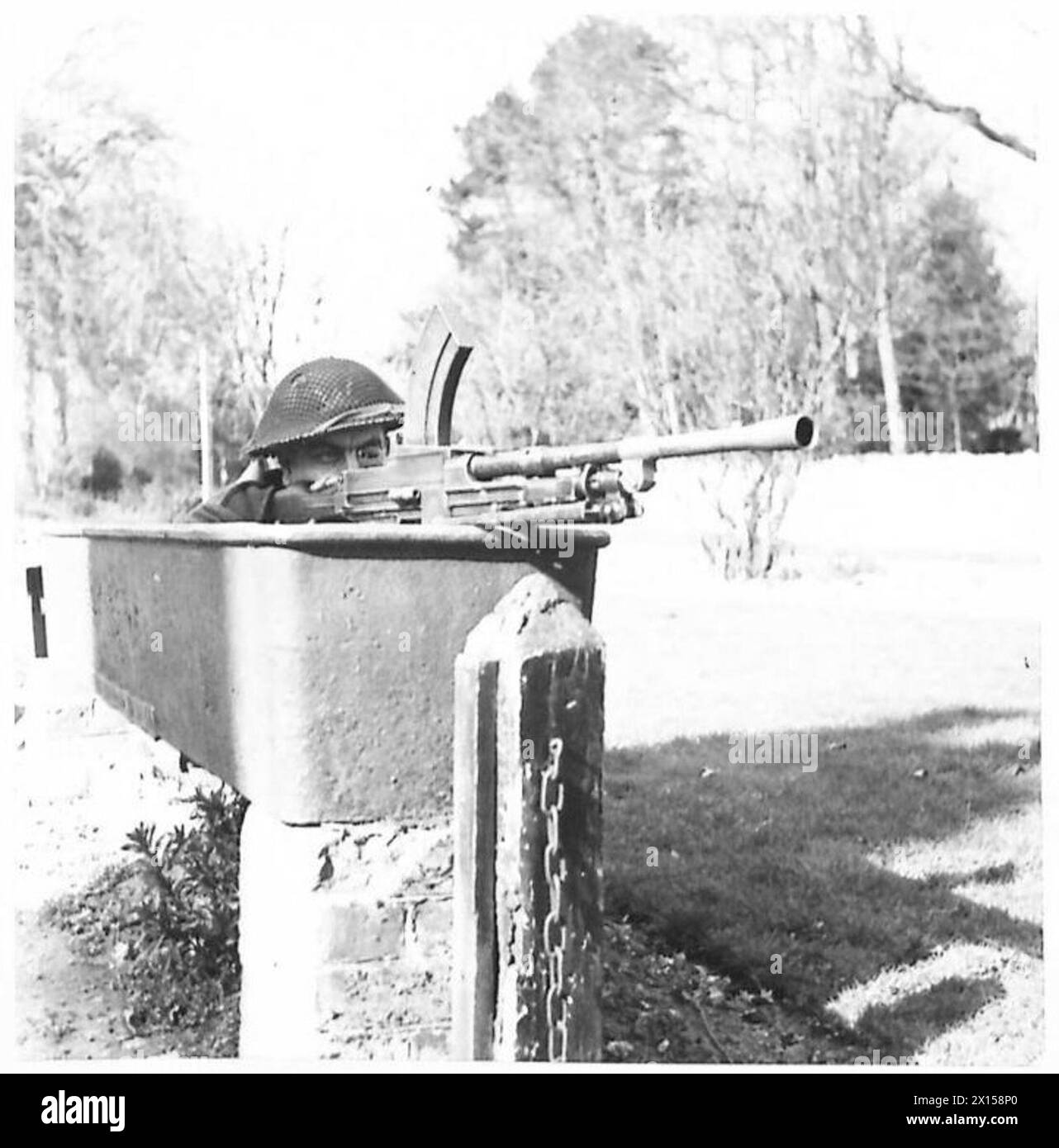 SPARTAN EXERCISE - A Bren gunner takes up position in a water trough ...