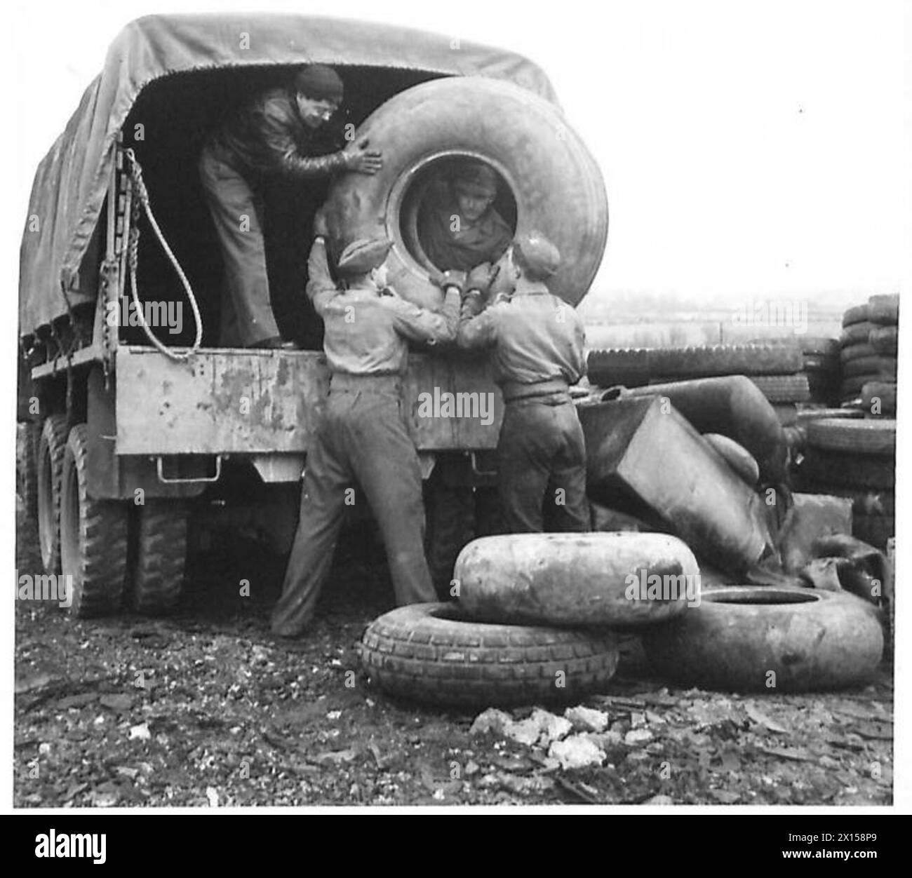 USA personnel and British soldiers unload unserviceable tyres at a ...