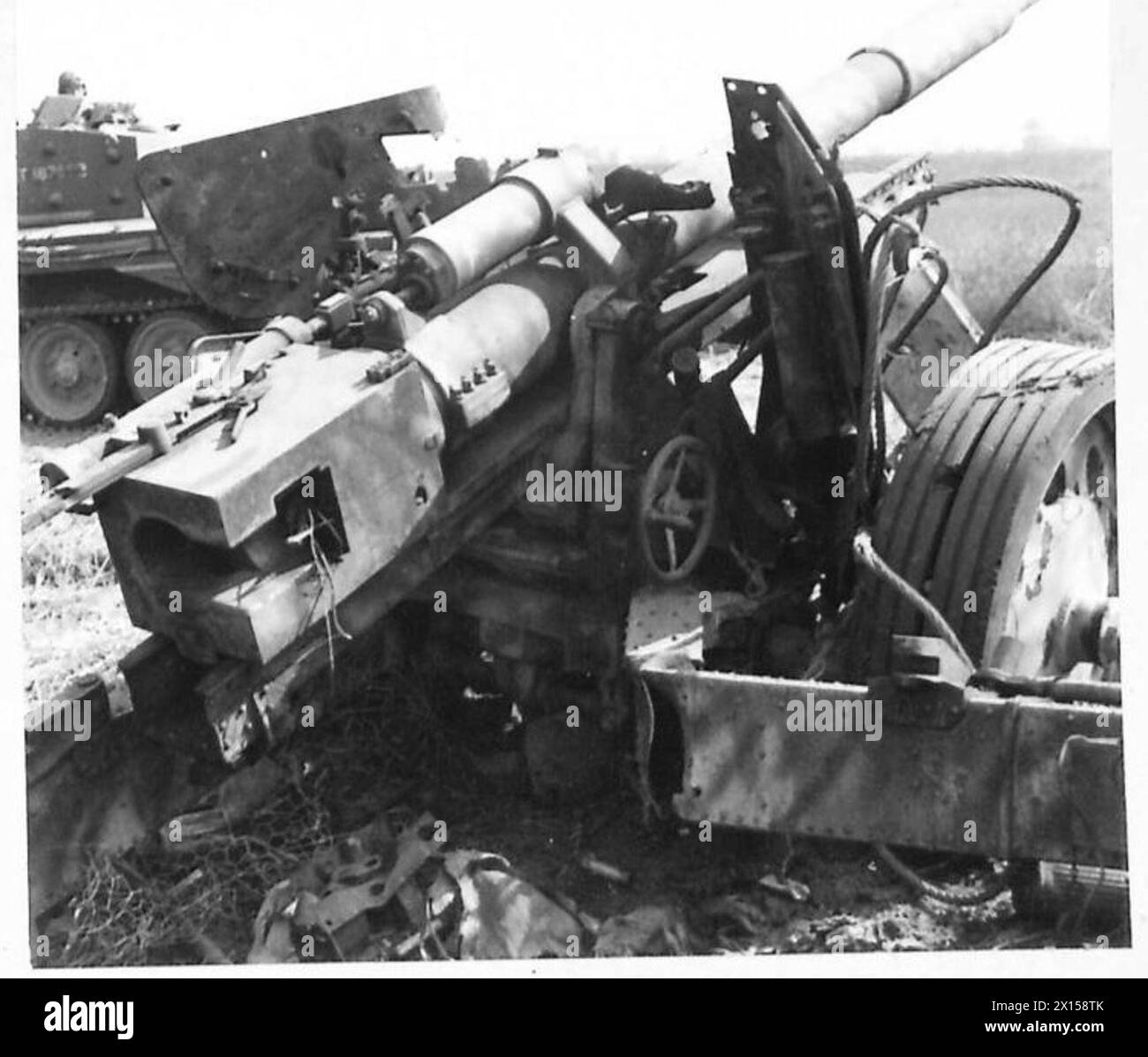 A knocked-out German Pak 43 anti-tank gun lies in the path of advancing ...