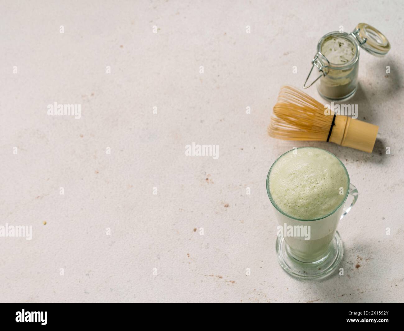 Matcha green tea latte in glass. Matcha latte on light background. Copy ...