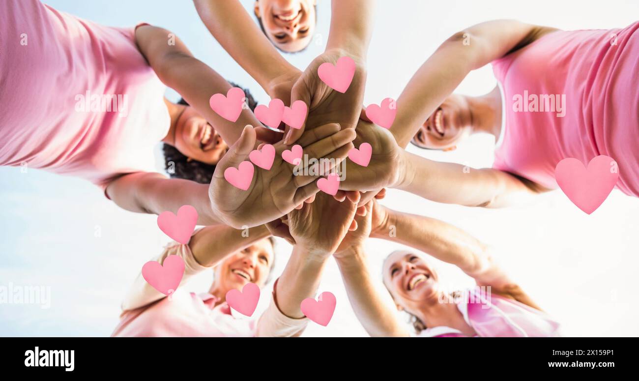 Image of hearts over happy diverse women teaming up Stock Photo - Alamy