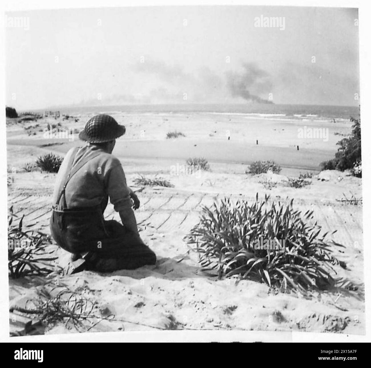 Corporal B. Lowings observes a destroyer laying a smokescreen at sea to ...