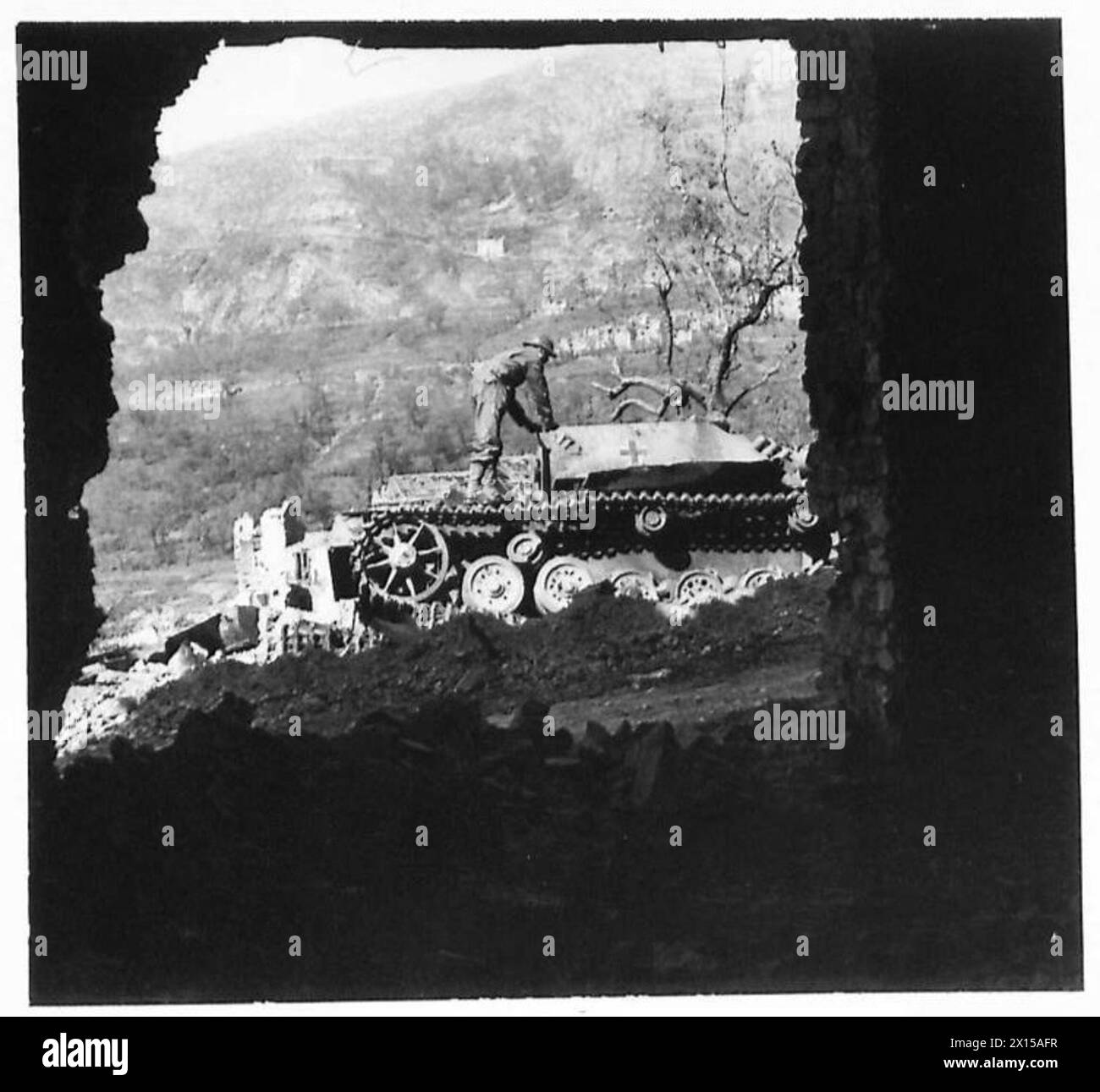 A French officer inspects a destroyed German tank in the town of ...