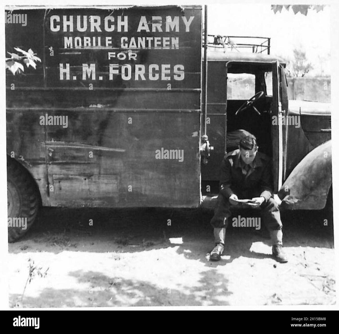 Captain B. Ives is seated on the running board of the Church Army ...