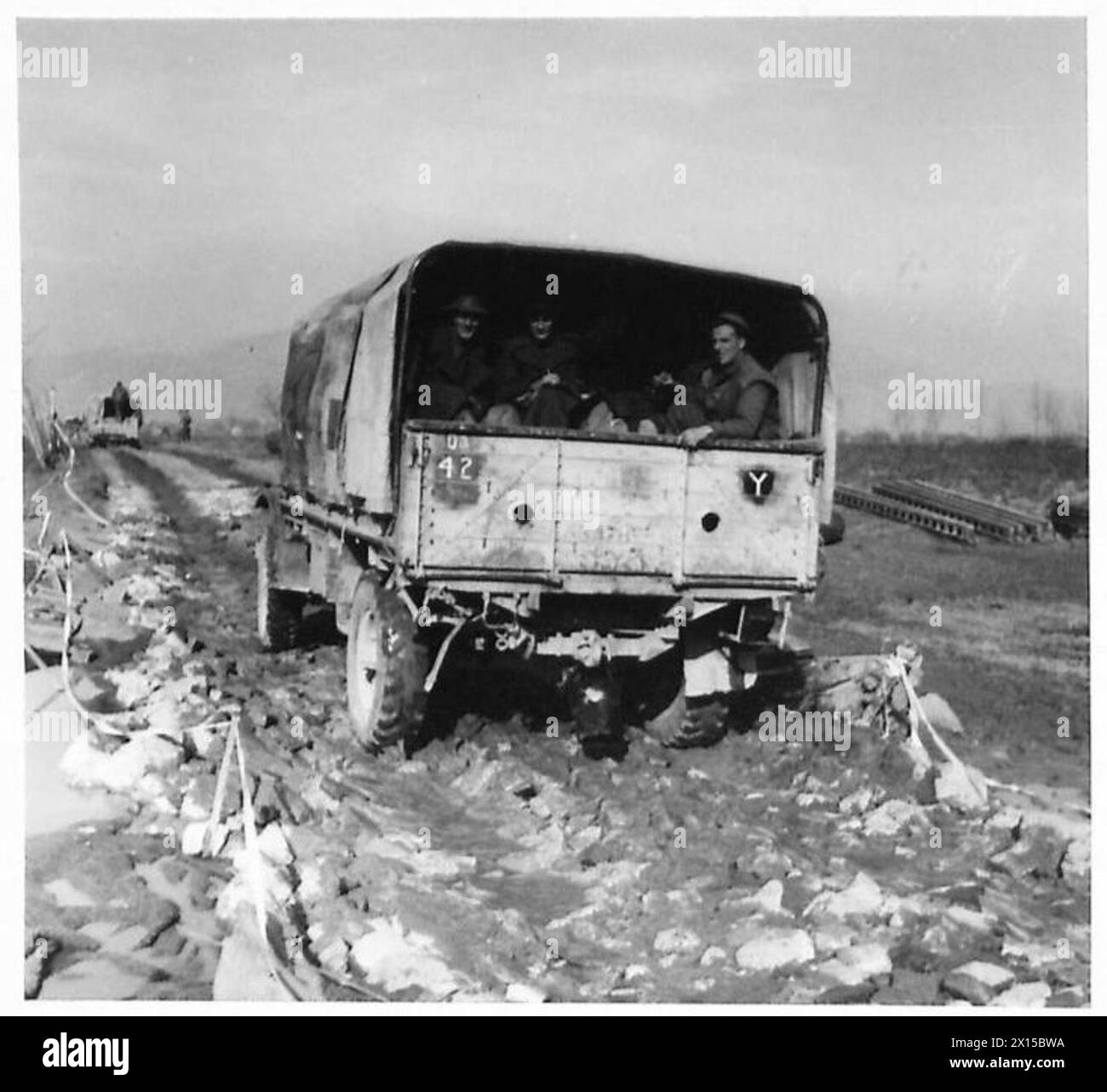 British Army vehicles and personnel are crossing a ford over the ...