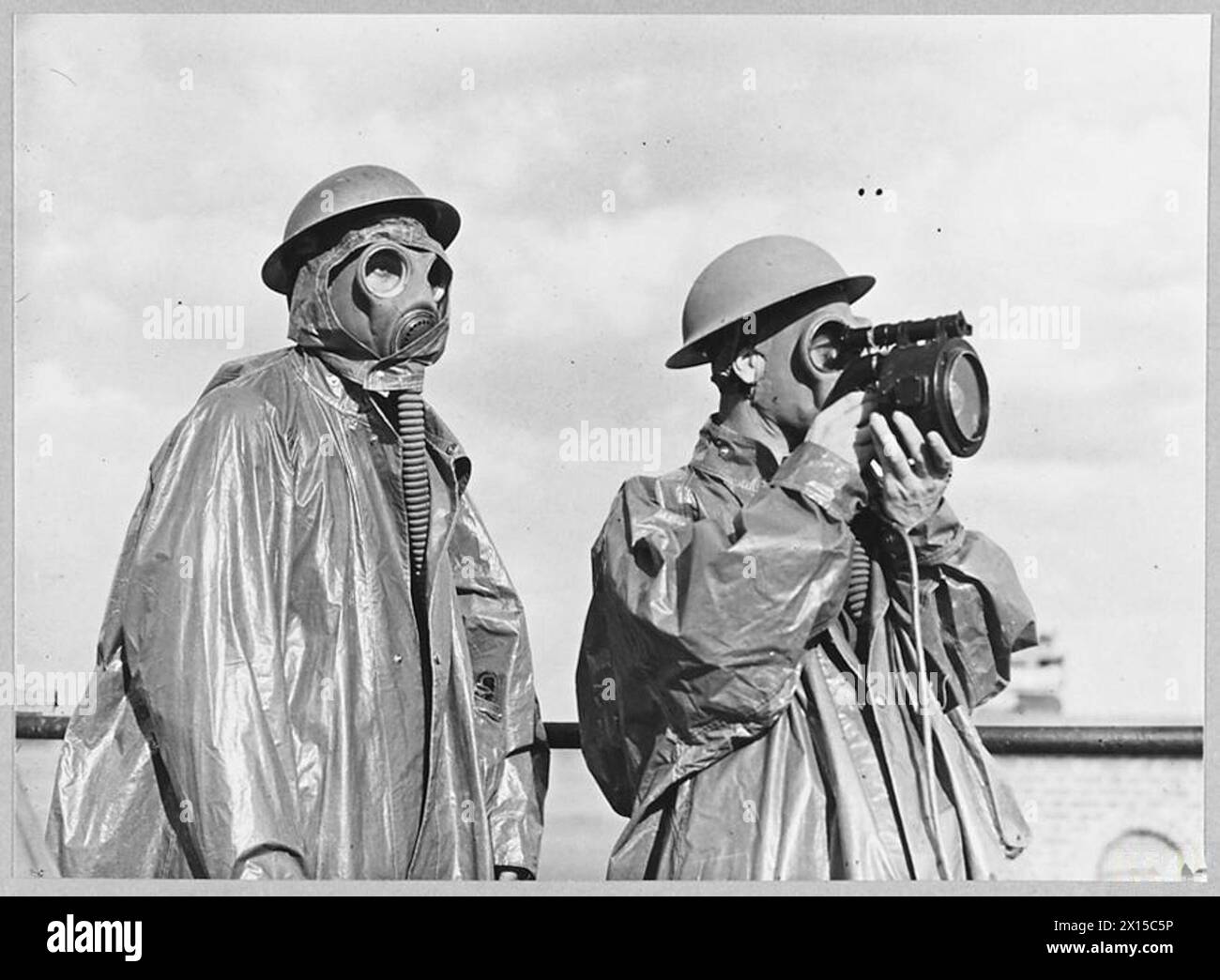 An RAF signaller uses an Aldis lamp while wearing an antigas cape and ...