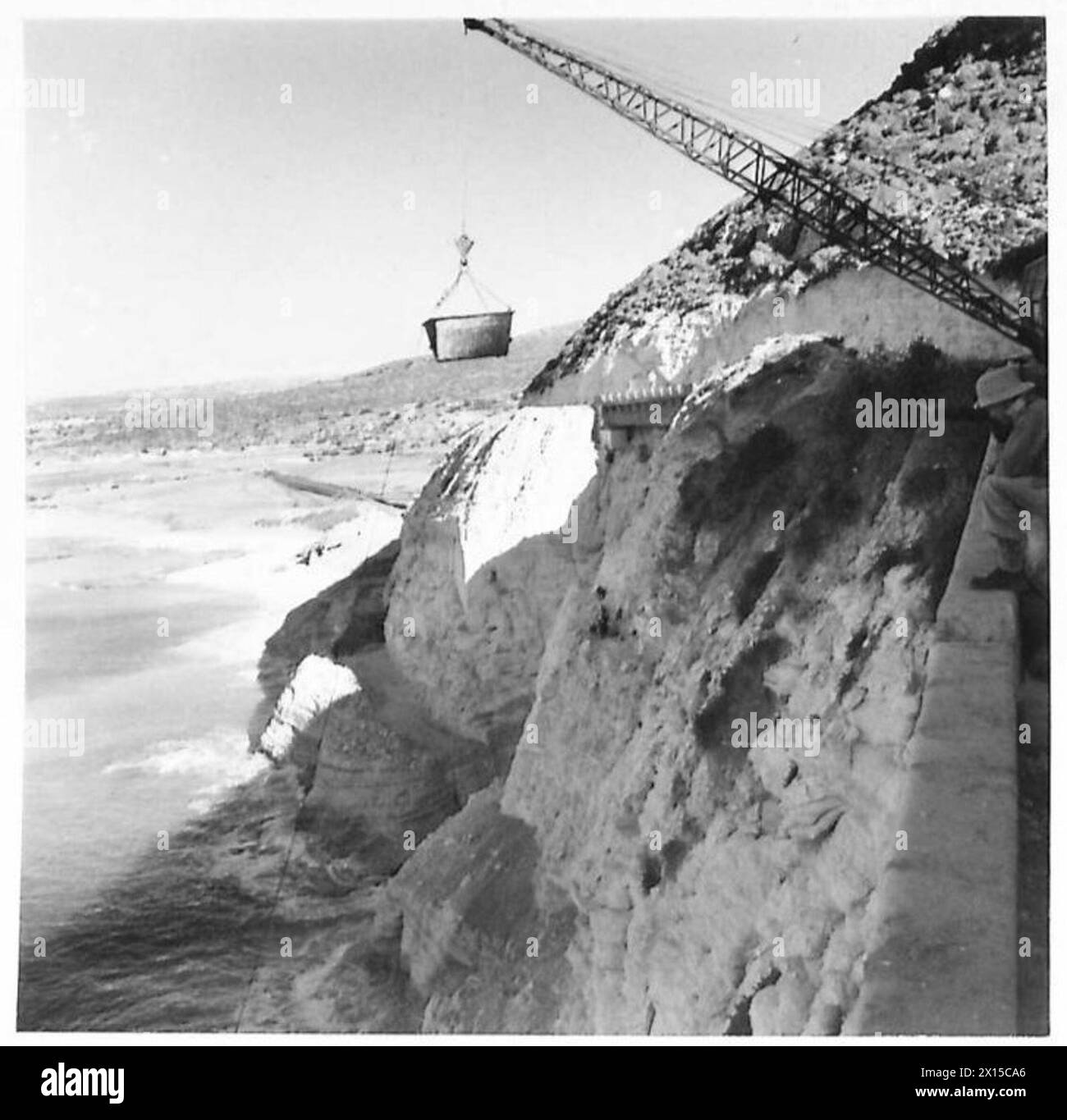 BUILDING THE HAIFA-TRIPOLI RAILWAY - The crane bucket being tipped over ...