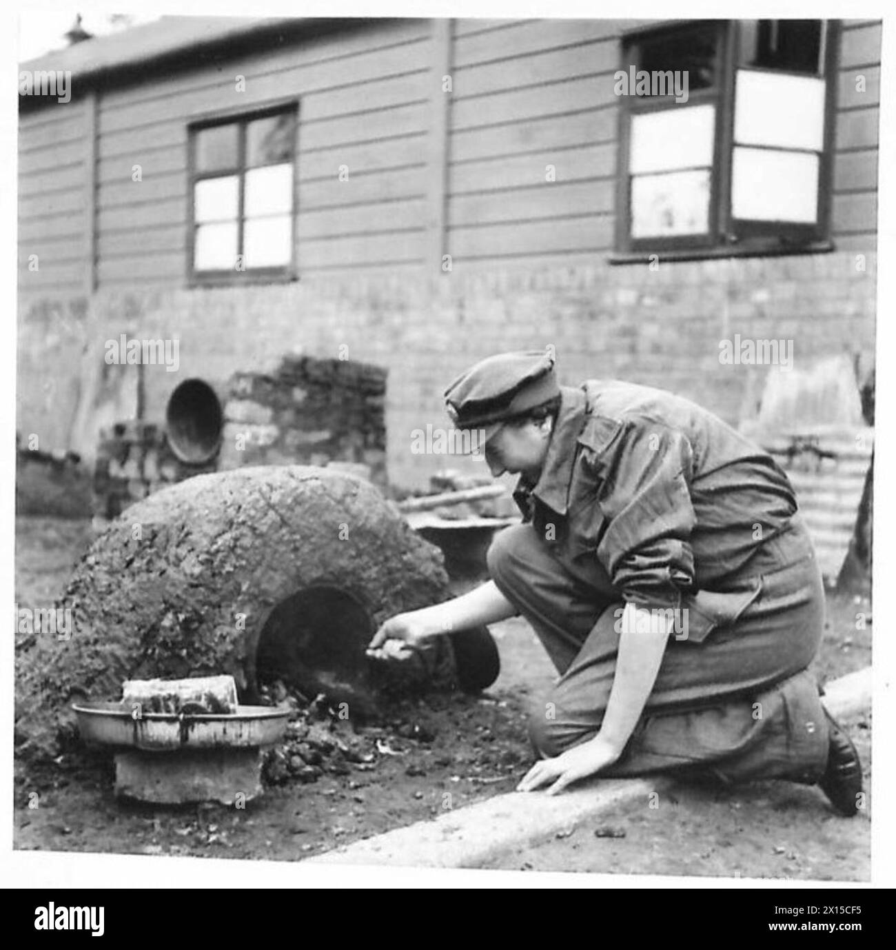 ATS COOKERY SCHOOL - An ATS cook rakes out the fire from a small field ...