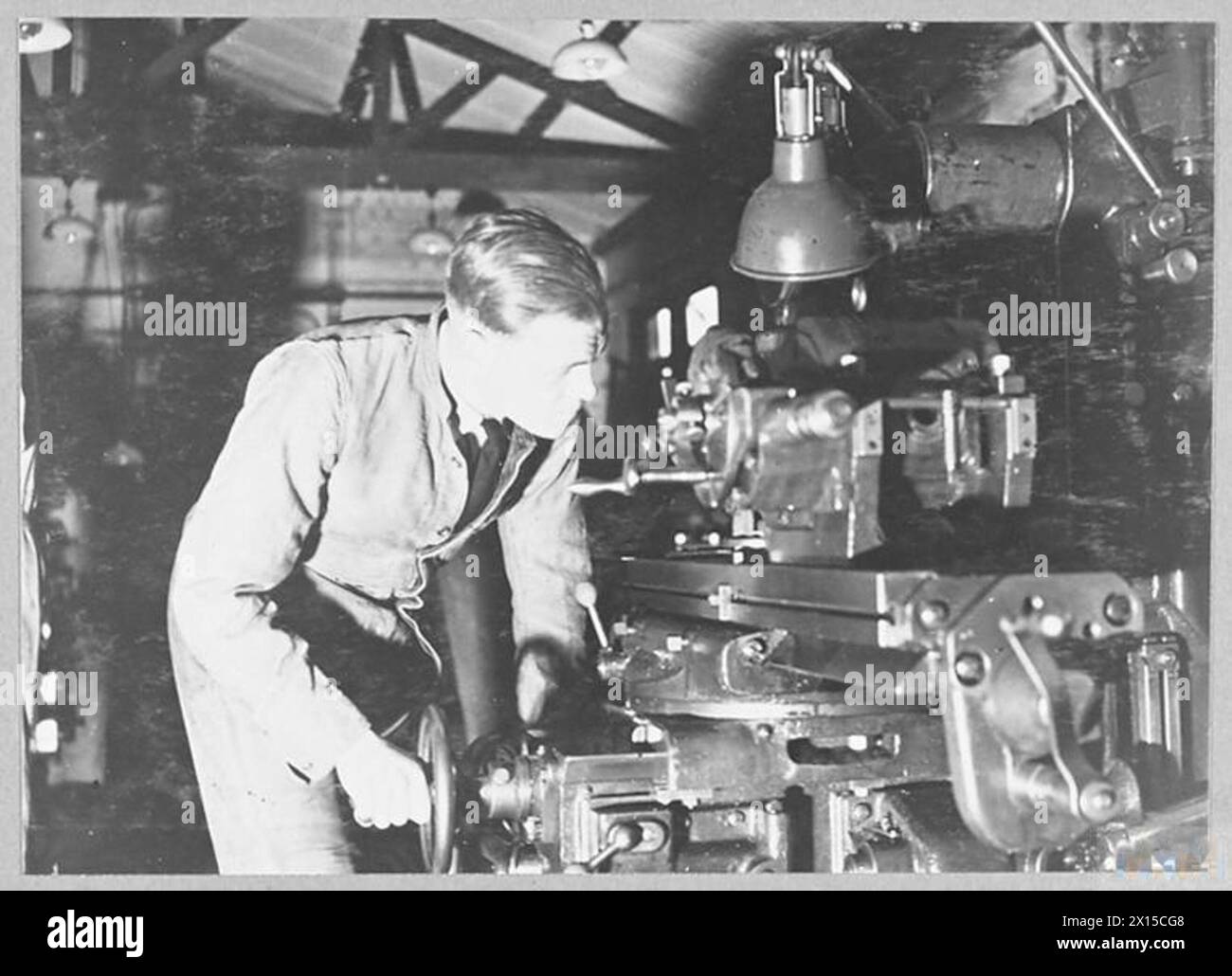 WORK AT AN R.A.F. STATION - Picture issued 1945 shows - A machine tool ...