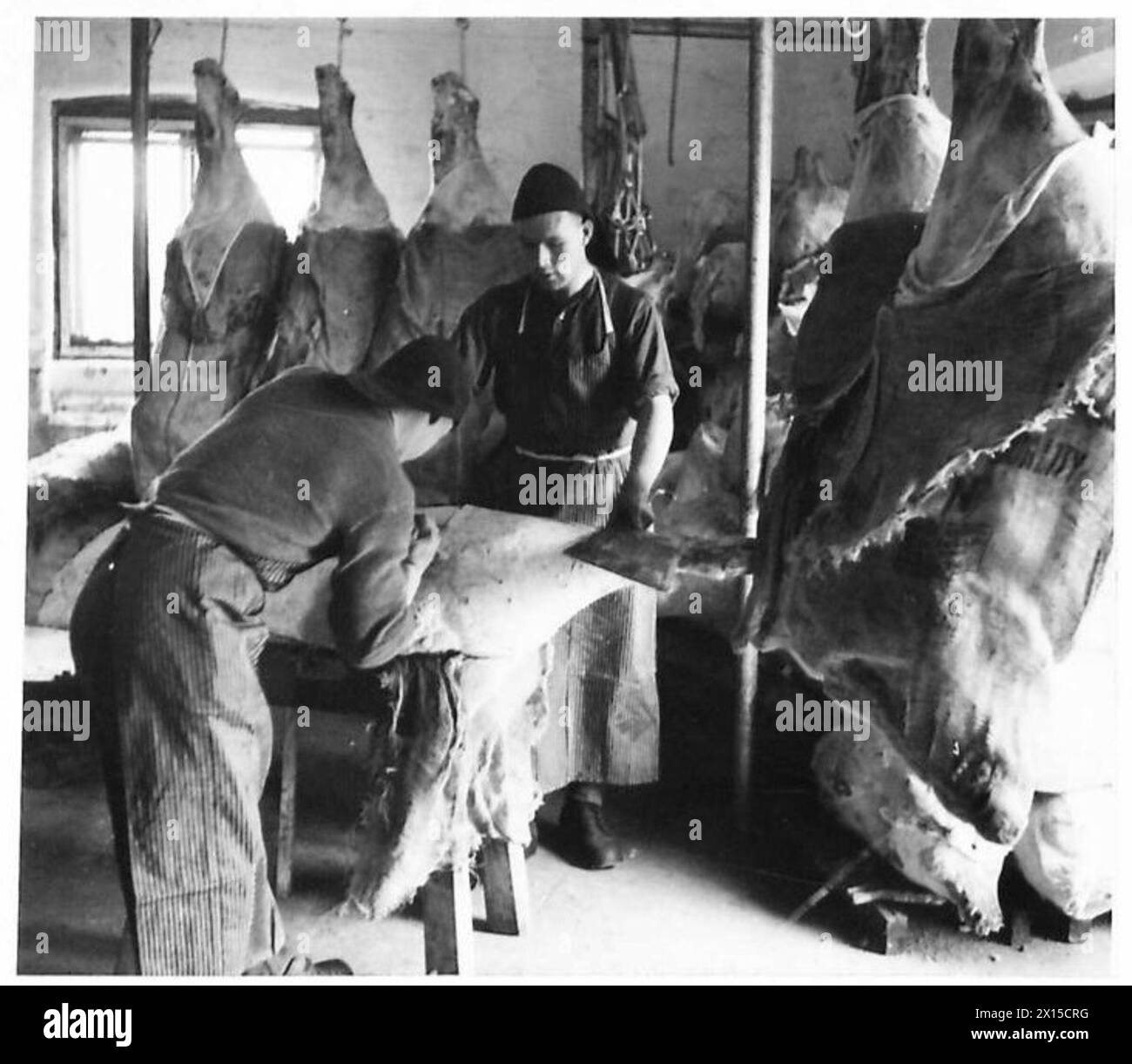 Royal Army Service Corps personnel cut and prepare joints of meat in ...