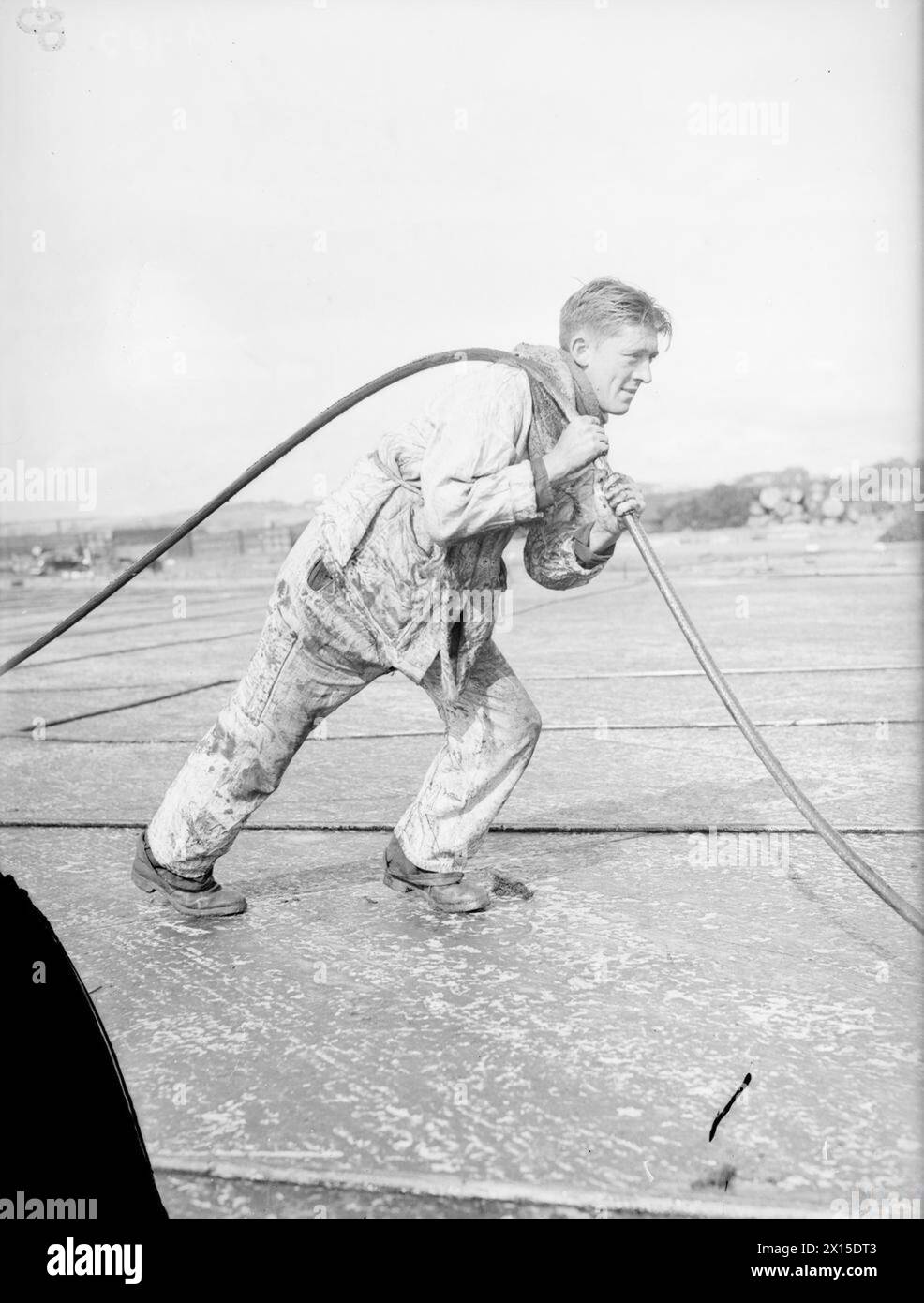 Workmen run out wire ropes of a net at a boom defence depot during ...